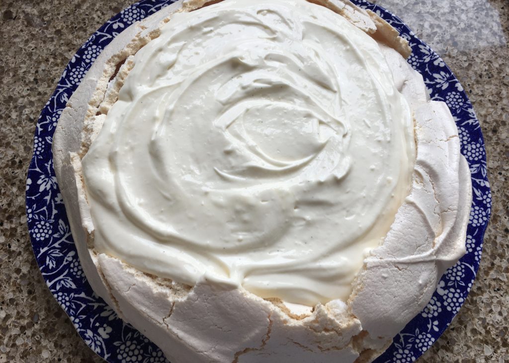 Custard filled pavlova topped with fresh strawberries and white ...